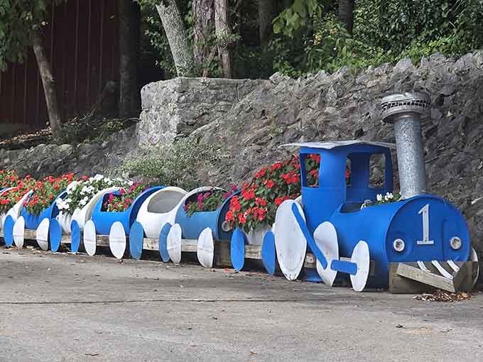 A cheerful train planter bursting with flowers adds whimsy to the farm's authentic agricultural atmosphere beautifully.