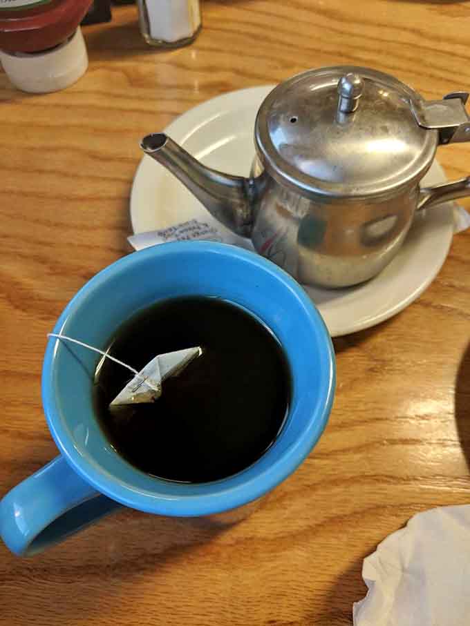 Hot tea in a proper pot, because even coffee drinkers deserve options at a civilized breakfast establishment.
