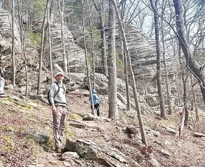 Adventurers navigate layered bluffs where every foothold tells a story written in sediment and stone across millennia.