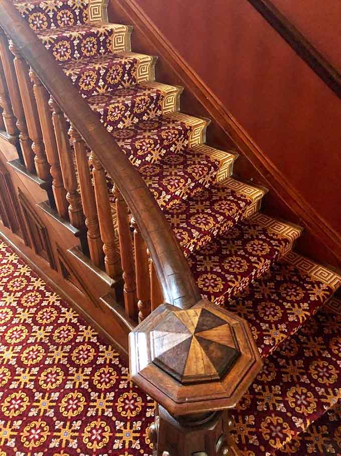 These grand stairs have witnessed countless footsteps, both earthly and possibly otherwise, ascending into mansion history.