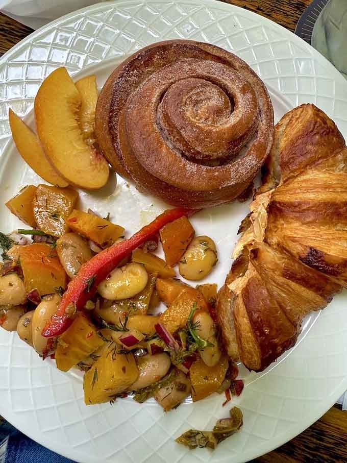 A cinnamon roll the size of your head alongside fresh fruit and croissant? Breakfast just became an all-day affair.