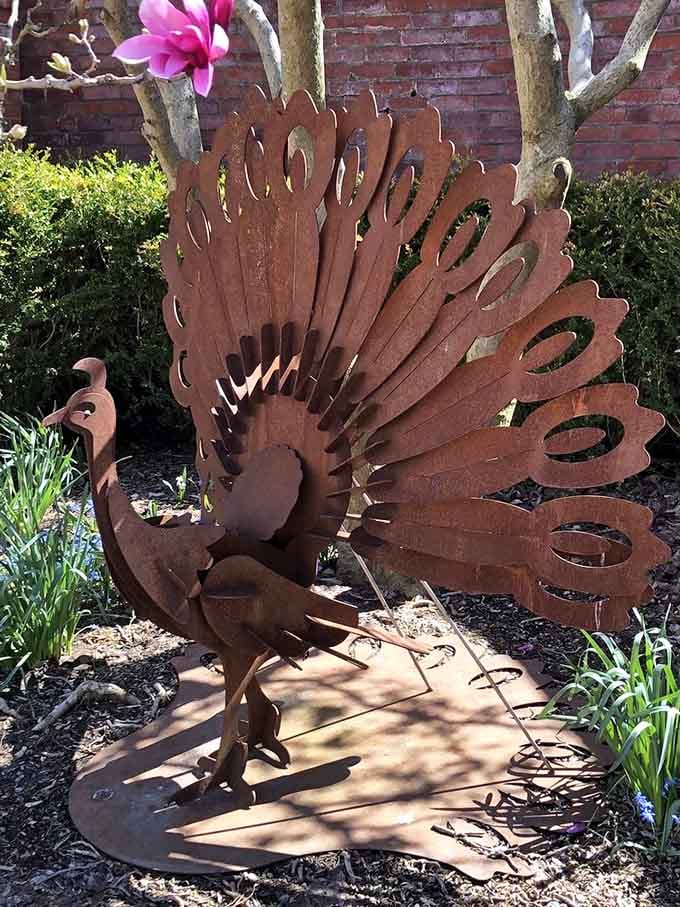 Garden sculptures add whimsy throughout the grounds, proving that art and nature make excellent roommates when properly introduced.