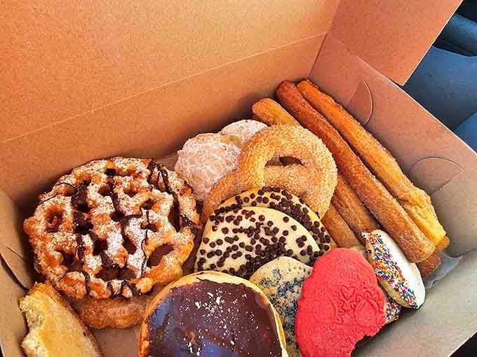 A cardboard box of pan dulce and churros that looks like a greatest hits album you can eat.
