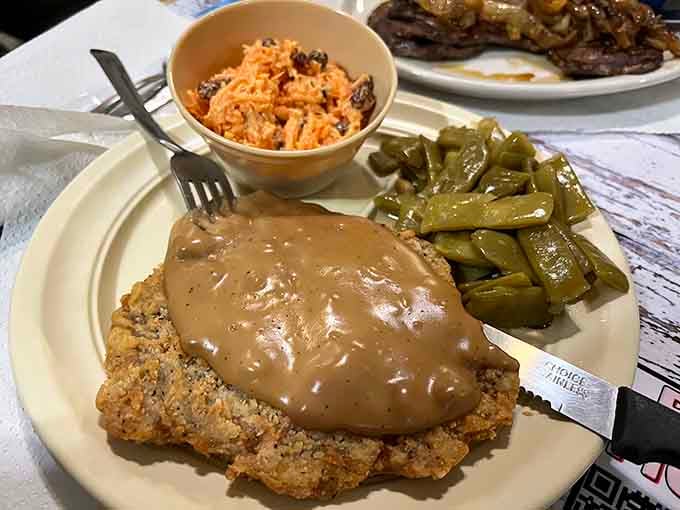 Country fried steak smothered in gravy with green beans and slaw, this is what Sunday dinner dreams are made of.