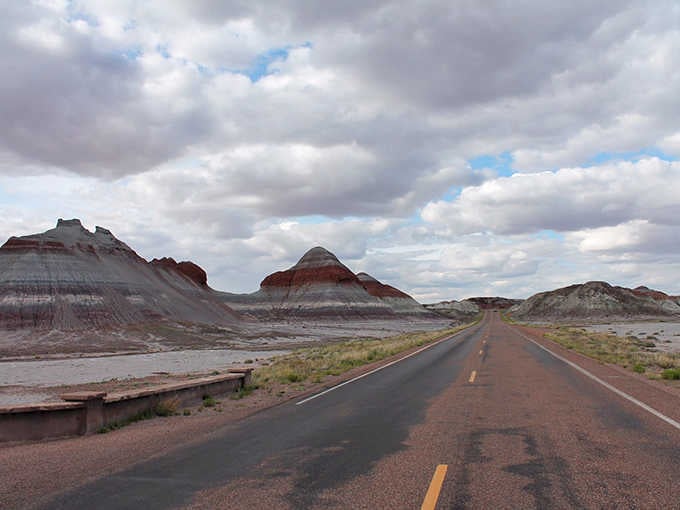That lonely highway cuts through the painted landscape like a ribbon through the world's most impressive gift wrapping.
