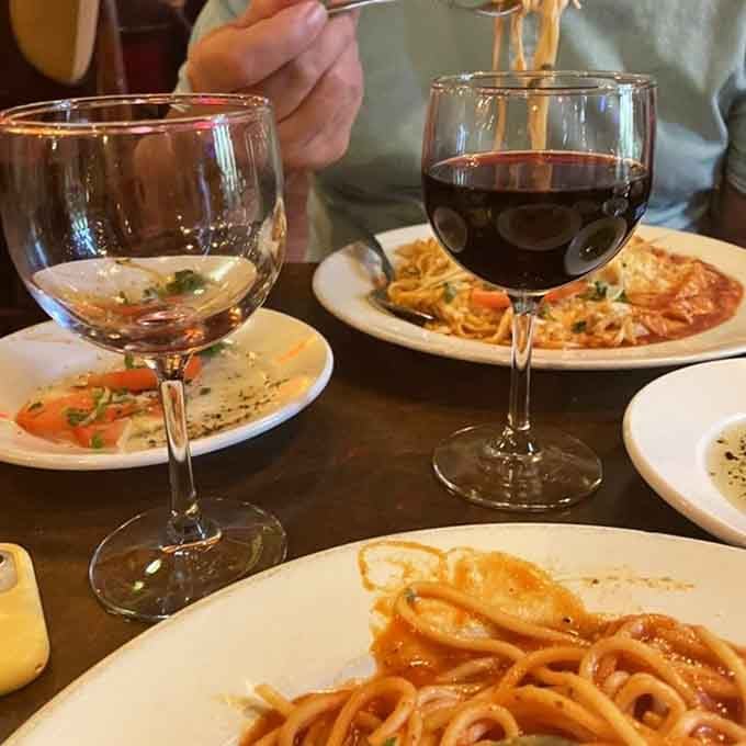 Wine glasses raised over plates of pasta is the international symbol for "life is good and we're doing it right."