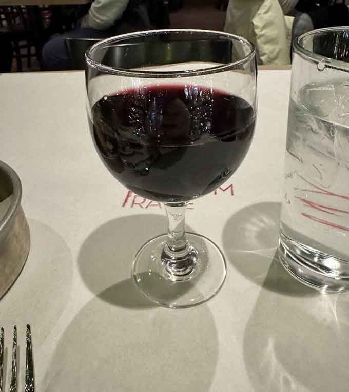 A proper glass of red wine, because even straightforward steakhouses understand the importance of a good pairing ritual.