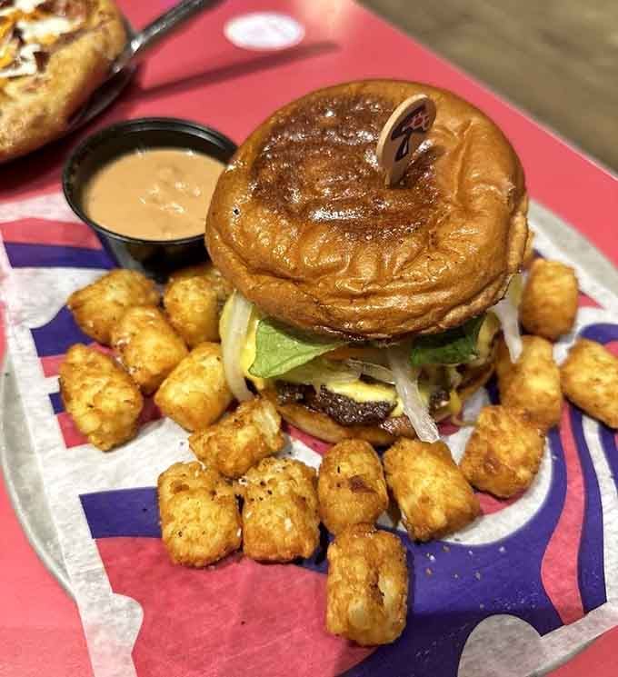 That pretzel bun burger surrounded by tater tots is basically comfort food giving you a warm hug.