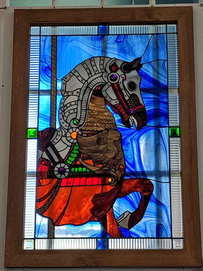 Stained glass carousel art that belongs in a gallery but somehow ended up making a museum even more magical.