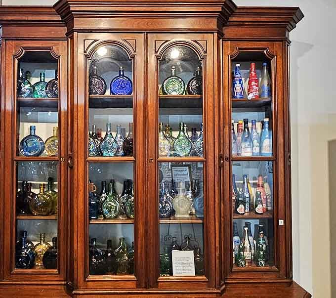 An elegant wooden cabinet displays rare bottles like precious jewels, because that's exactly what they are to collectors.