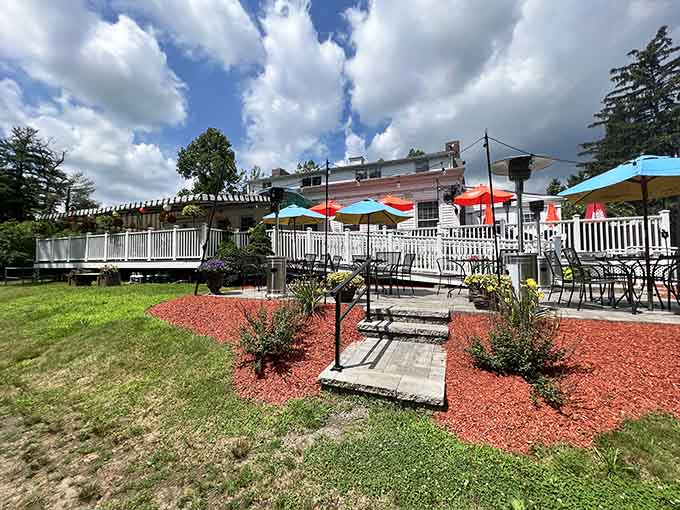 Colorful umbrellas dot this inviting patio where summer dining feels like a vacation without the airport security hassle.