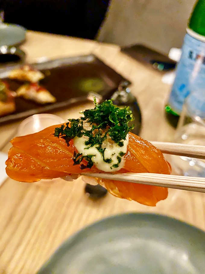 Salmon nigiri topped with delicate garnishes that transform simple fish into an elegant bite worth savoring slowly and deliberately.
