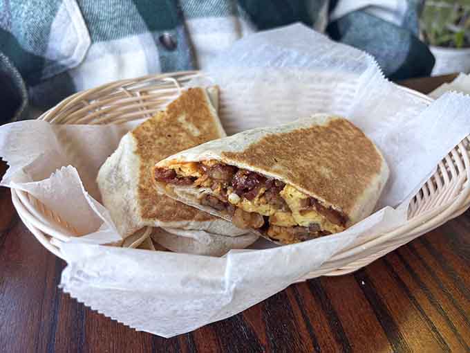 A breakfast burrito stuffed so generously it requires strategic planning to eat without making a complete mess.