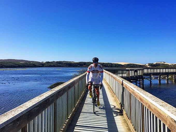 Cyclists cruise the boardwalk where wetlands meet ocean in perfect Central Coast harmony.