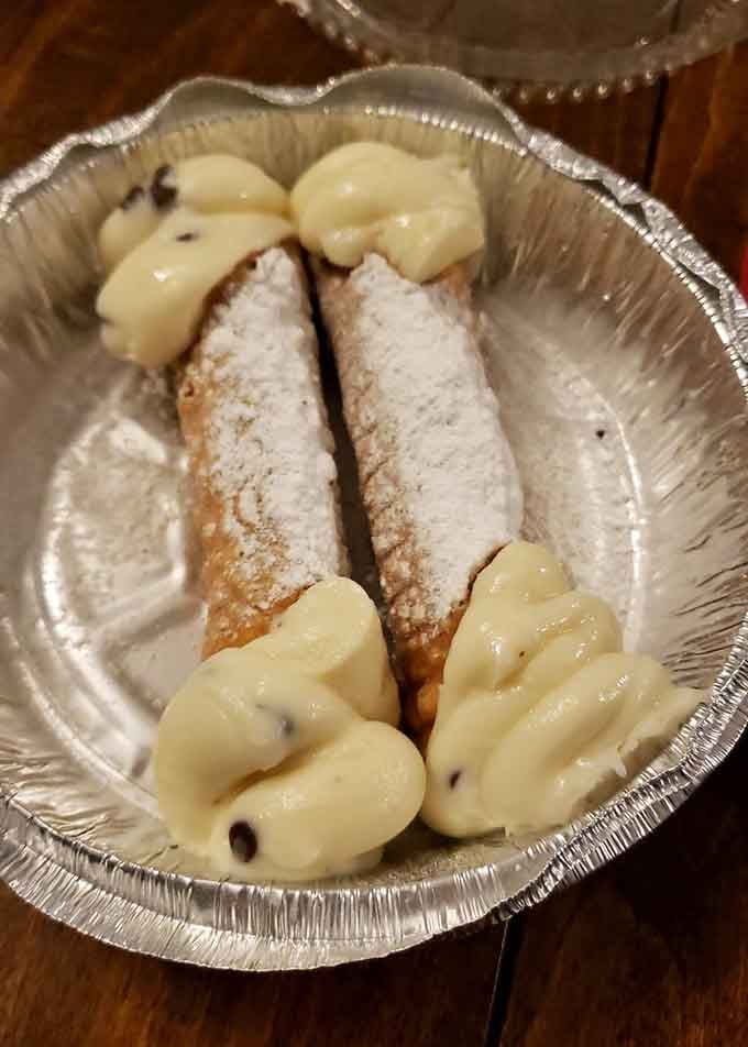 Crispy cannoli shells cradling sweet ricotta filling, dusted with powdered sugar like little edible clouds of Italian joy.