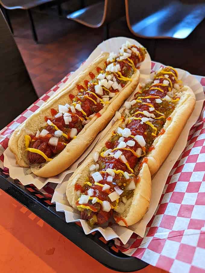 Three foot-longs dressed to the nines with mustard, ketchup, and onions, ready for their close-up and your appetite.