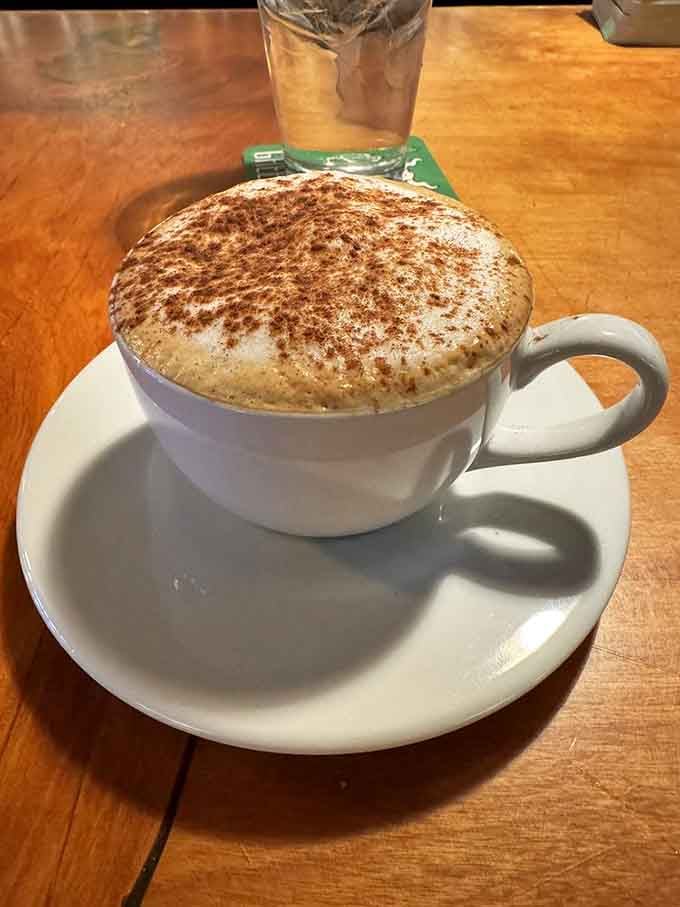 A cappuccino topped with cinnamon and served with care—because some mornings require foam art and caffeinated comfort in equal measure.