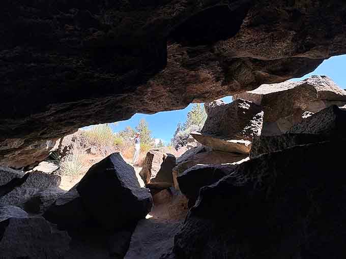 Jagged volcanic boulders scattered across the cave floor tell stories of ancient eruptions and flowing fire.