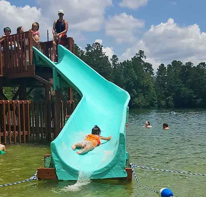 The turquoise slide gleaming in the sunshine, ready to launch you into refreshing lake water with maximum splash potential.