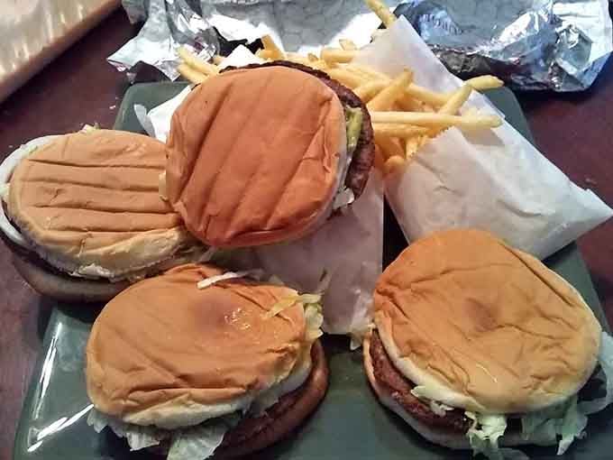 Three burgers wrapped and ready, like edible presents you get to open with your mouth.