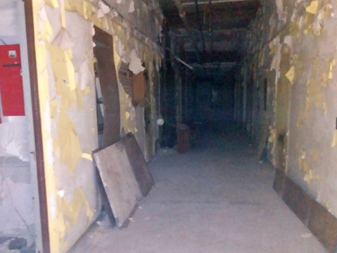 Peeling paint layers tell decades of stories in this corridor, each strip revealing another era of medical history beneath.
