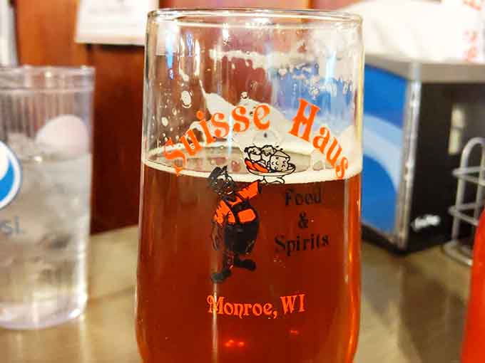 A branded Suisse Haus glass filled with amber beer. This is what belonging somewhere feels like, one sip at a time.