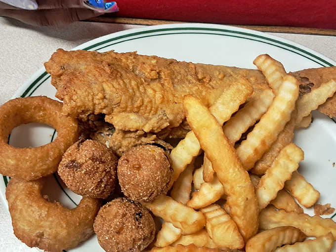 Fried fish that looks like it just won the lottery, complete with hush puppies and onion rings.