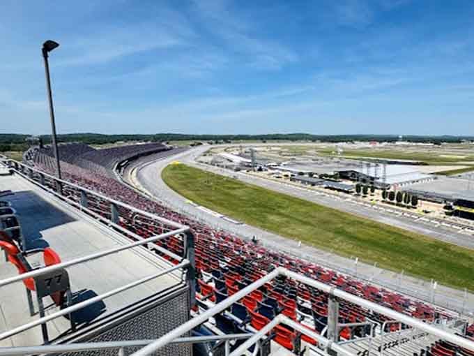 The grandstands tower above the track like steel mountains, offering views that make your heart race before cars do.