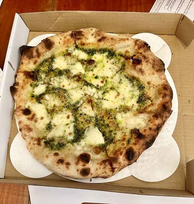 Vibrant green pesto swirled across melted cheese creates a flavor combination that'll haunt your dreams in the very best way.