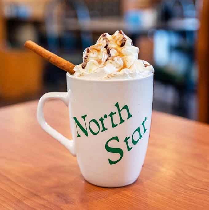 Whipped cream, chocolate drizzle, and a cinnamon stick make this mug pure liquid happiness.