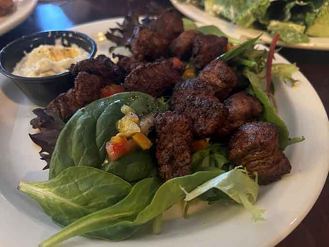 Blackened steak bites arranged on fresh greens prove that healthy eating and Gothic ambiance aren't mutually exclusive concepts after all.