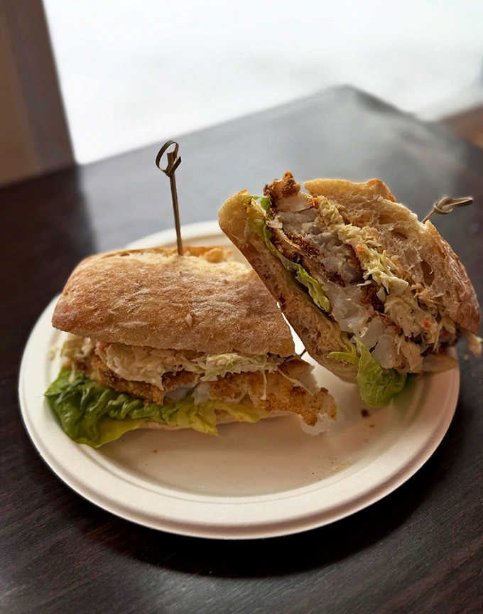 Crispy fish nestled between bread with fresh greens shows that even seafood gets the royal treatment here.