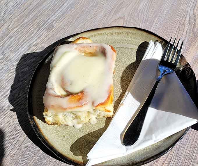 This cinnamon roll is so generously frosted, it deserves its own chapter in your Auburn food story.