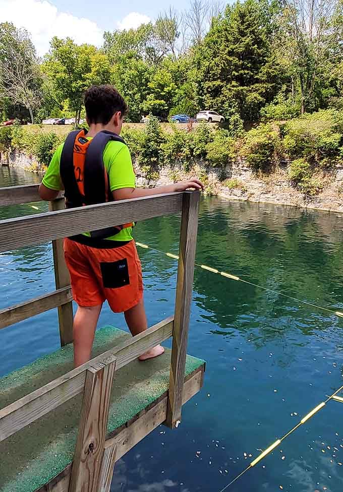 The moment before the plunge, when anticipation meets that refreshingly cool quarry water below.