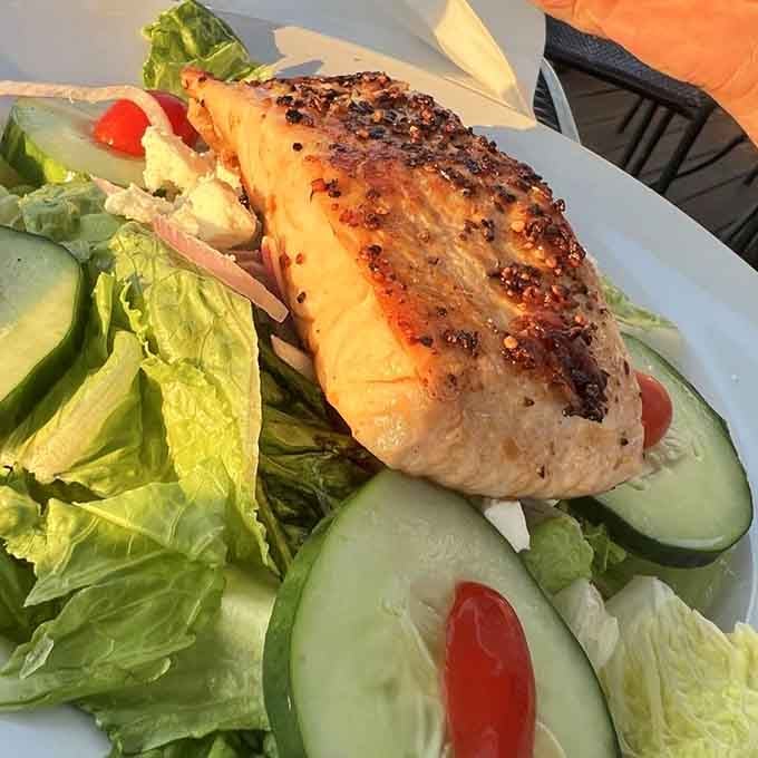 Perfectly seared salmon perched atop fresh greens: the kind of salad that makes vegetables feel victorious.