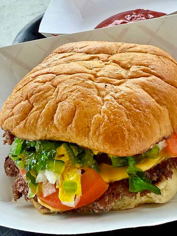 This burger means business with its generous toppings, showing Woofies doesn't play favorites between beef patties and franks.