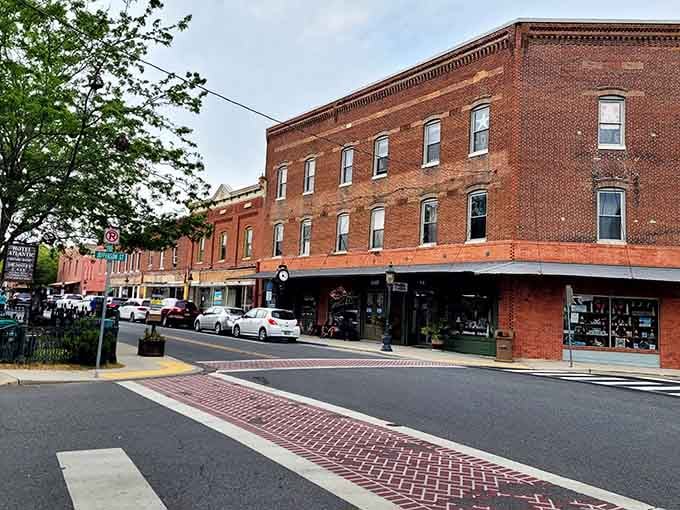 Historic brick buildings anchor this downtown where crosswalks connect past and present in one beautifully preserved main street scene.