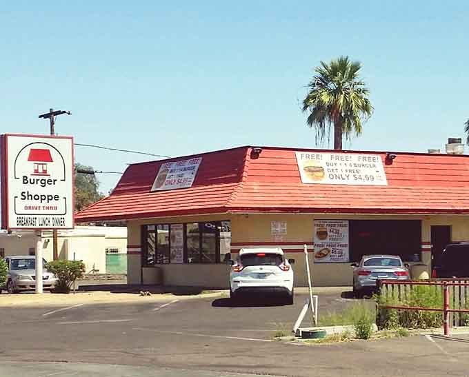That cheerful red roof and palm tree backdrop scream classic Arizona burger joint where locals have gathered for decades.