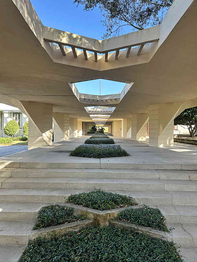 Frank Lloyd Wright's geometric genius creates dramatic shadows and angles that transform concrete into pure architectural poetry under blue sky.