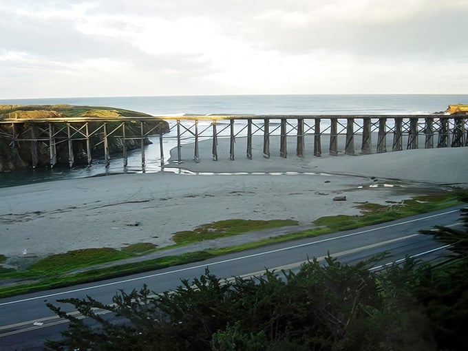 This weathered wooden trestle stands sentinel over tidal flats, a testament to engineering from a bygone railroad era.