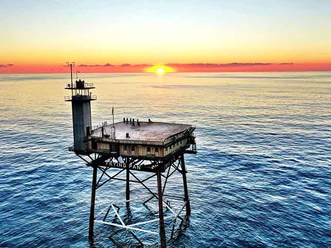 Dawn breaks over this solitary platform standing guard in the Atlantic, where the ocean meets sky in perfect stillness.