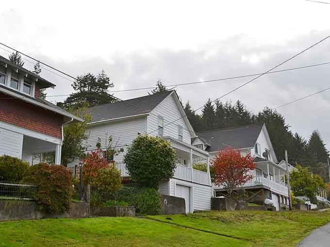 Classic white homes climb the hillside in neat rows where neighbors still wave from their porches every single day.