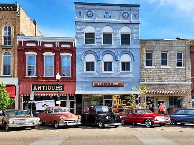 Classic cars parked along antique shops create a scene that looks like it rolled straight out of "American Graffiti."
