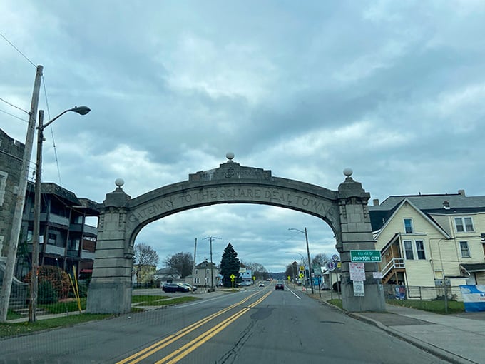 The Square Deal arch frames the road ahead like a gateway to simpler times when handshakes meant something and neighbors knew each other.