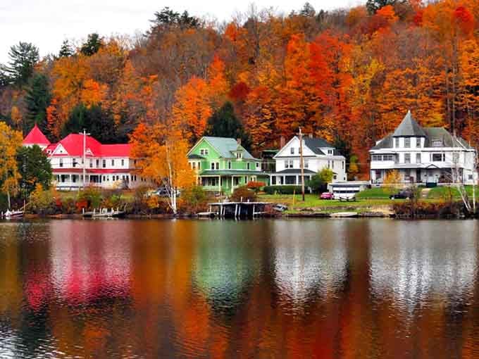 Grand lakeside homes reflect in still water like a postcard your grandmother would've sent.