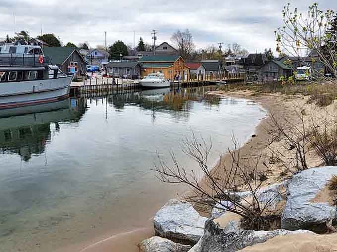 Leland's working harbor shows weathered fishing shanties and calm waters where commercial boats still earn their keep daily.