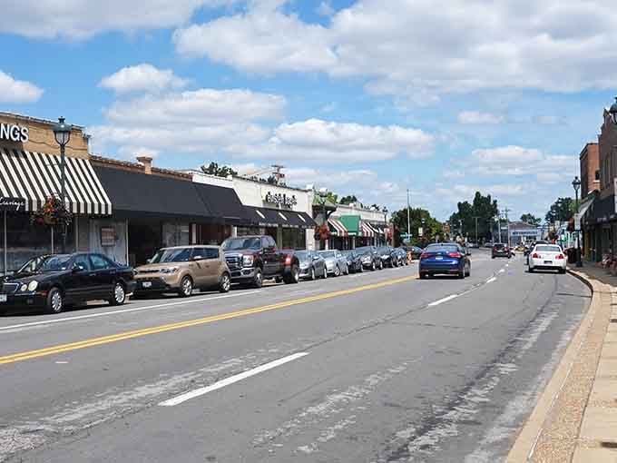 Striped awnings and parked cars line streets where shopping still means chatting with actual humans, not algorithms.