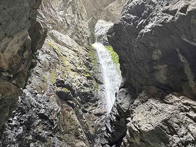 Framed by canyon walls, this hidden waterfall rewards those willing to wade through cold mountain streams.