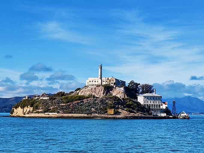 Alcatraz sits surrounded by choppy blue waves, a rocky fortress that once held America's most notorious criminals captive.