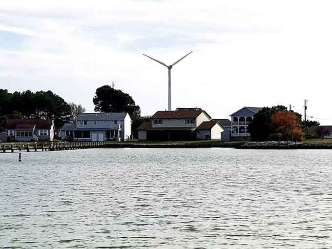 That wind turbine spins above quiet homes, mixing old-fashioned waterfront living with newfangled technology in perfect harmony.